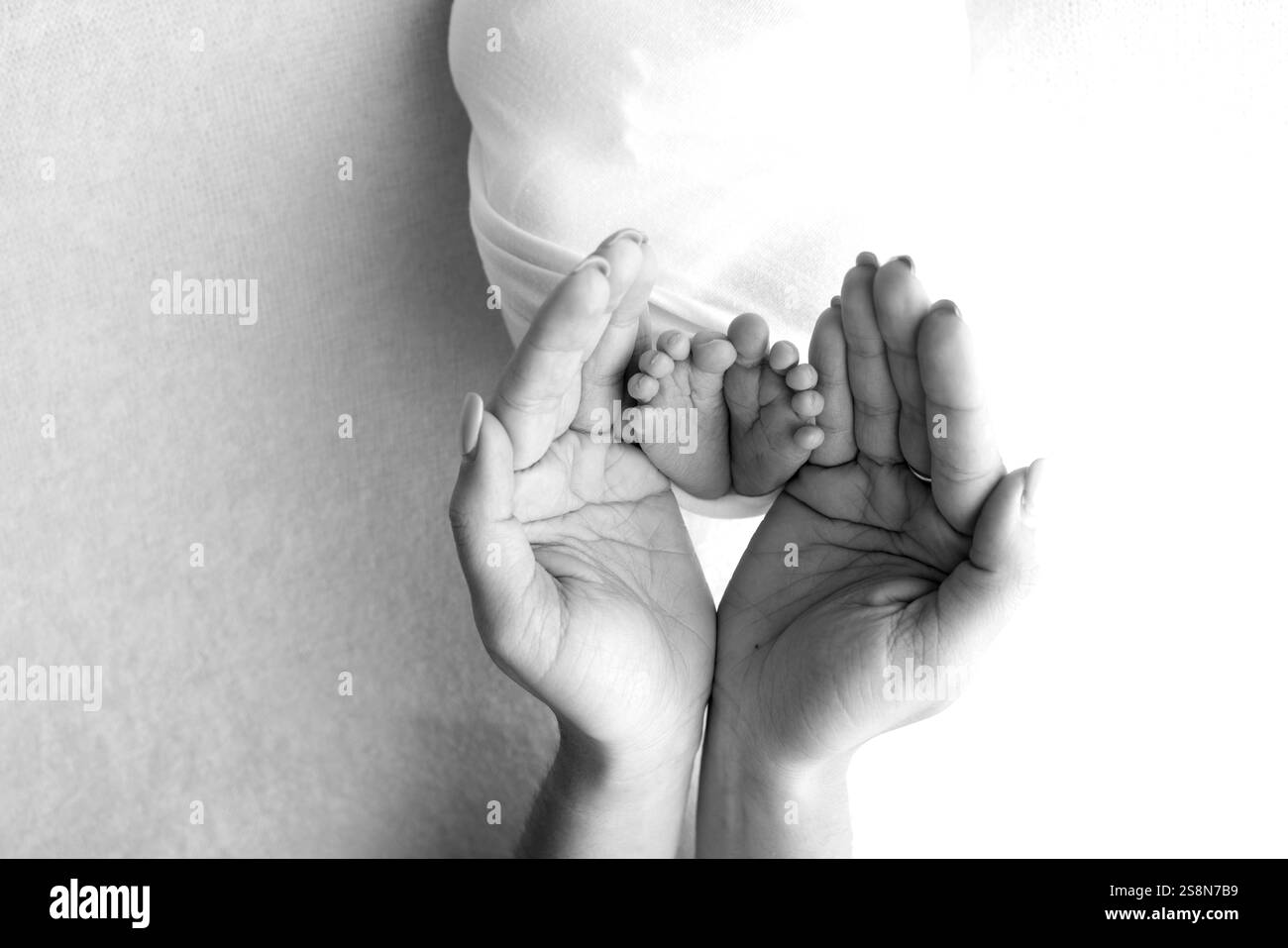 The palms of the parents. A father and mother hold the feet of a ...