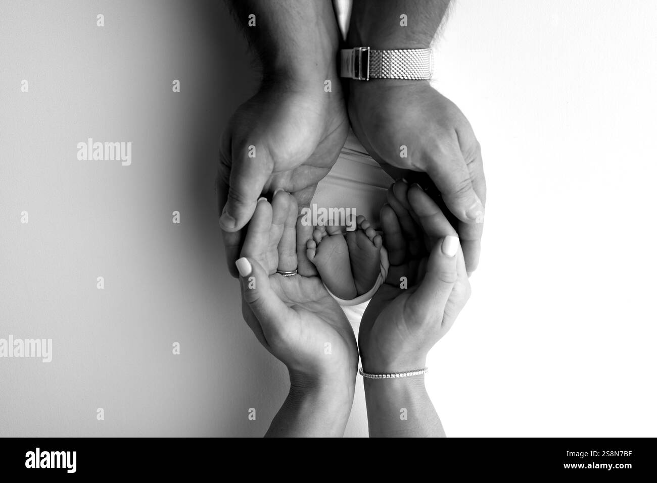 The palms of the parents. A father and mother hold the feet of a ...