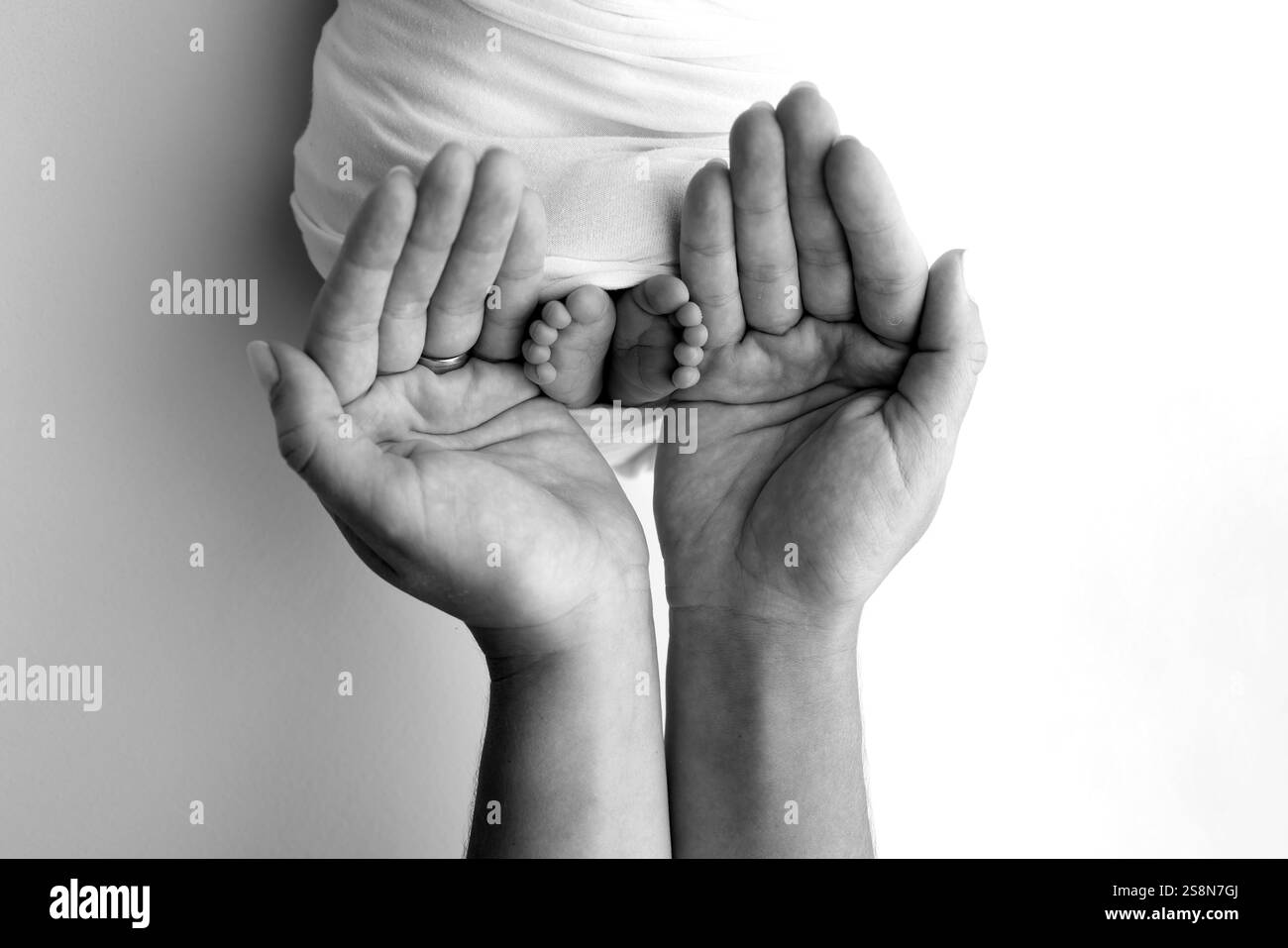 The palms of the parents. A father and mother hold the feet of a ...