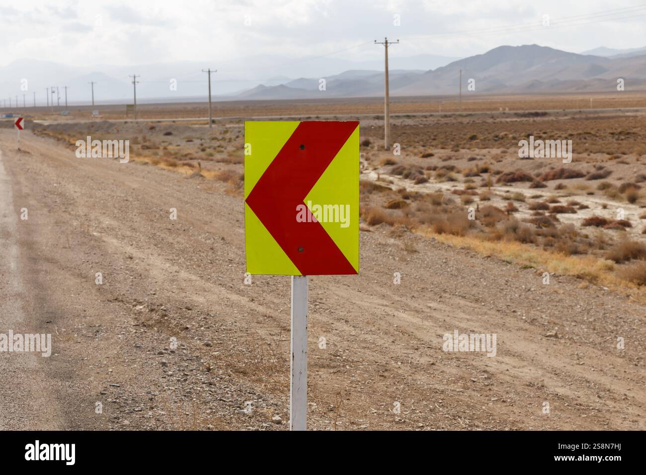 A bright warning sign indicates a sharp left turn on Gorgan Bojnord ...