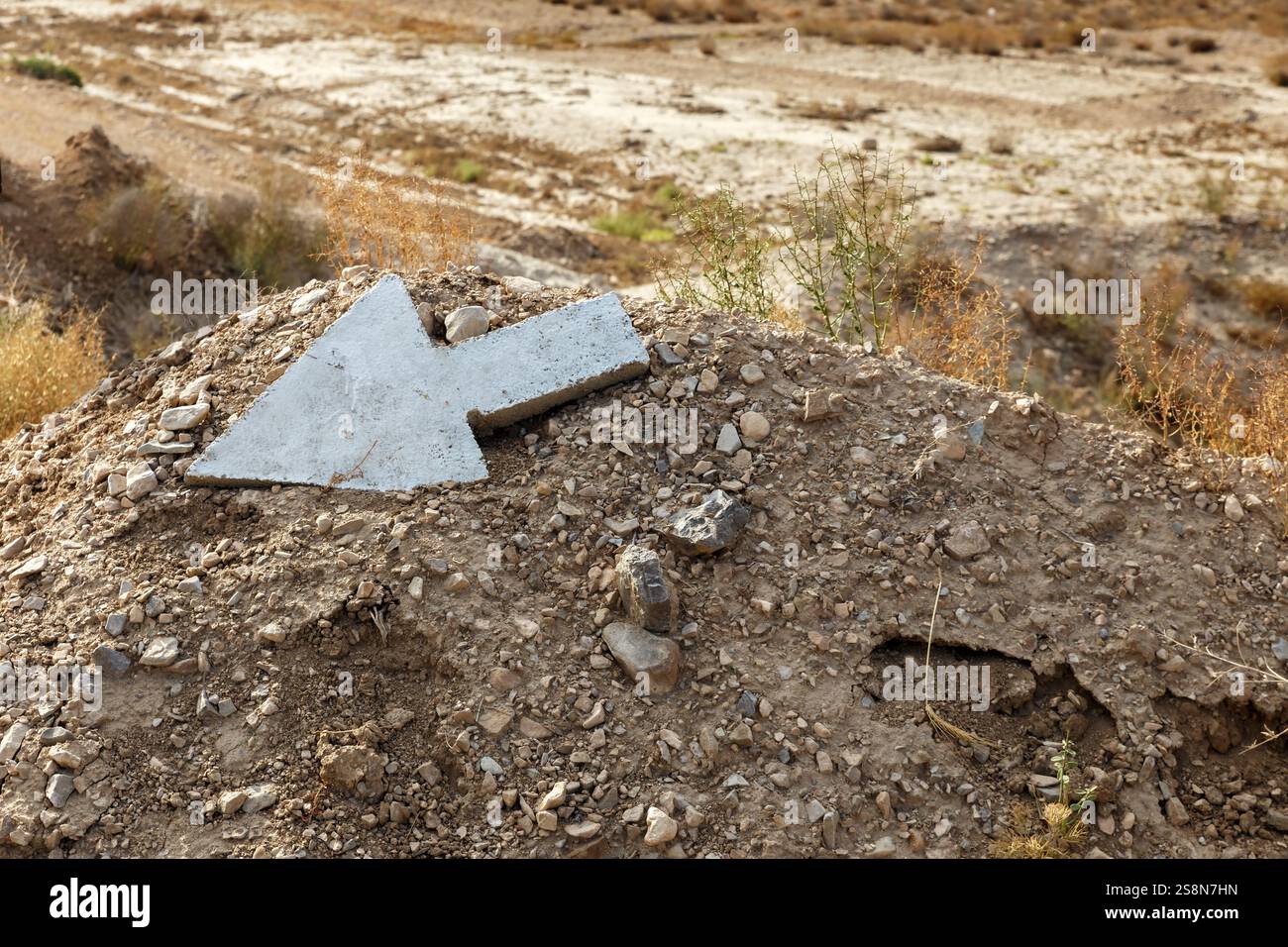 A concrete arrow marker directs travelers on the Gorgan Bojnord road in ...