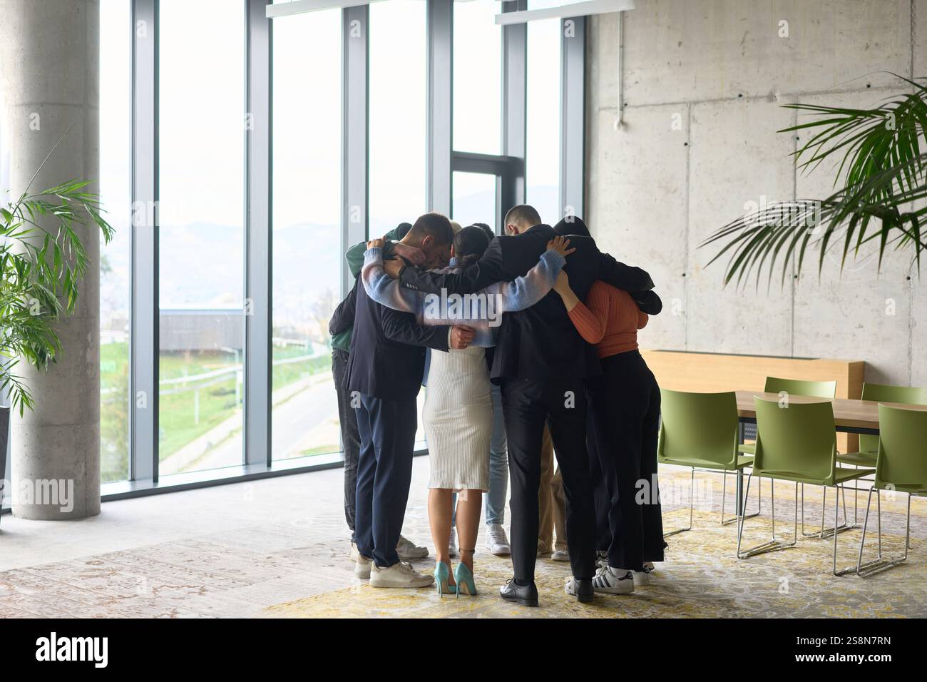 A diverse group of professionals standing in a supportive circle ...