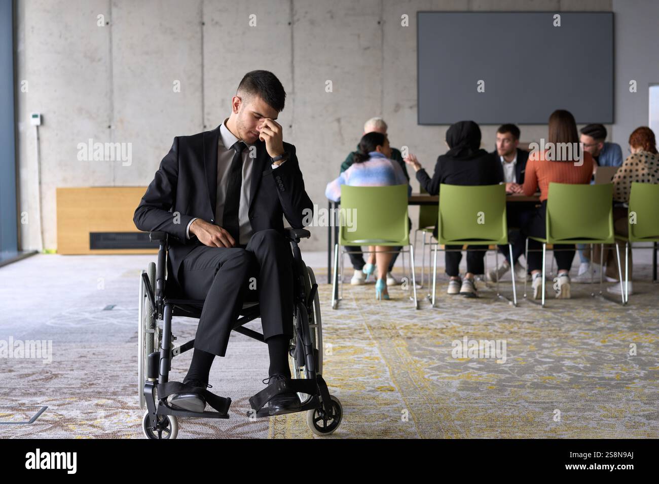 A sad and disheartened director in a wheelchair sitting alone in a ...