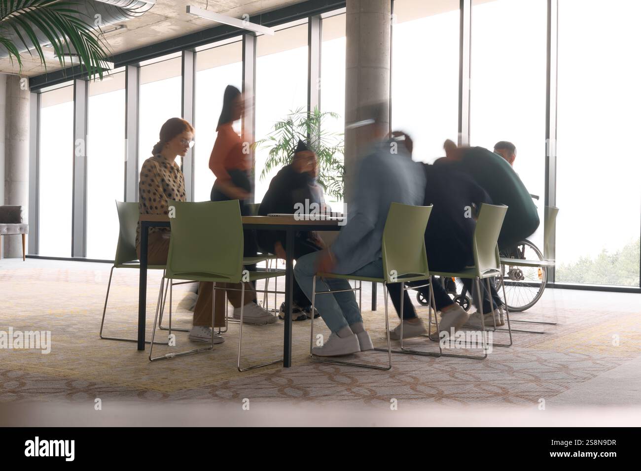 A diverse business team, working urgently around a conference table ...