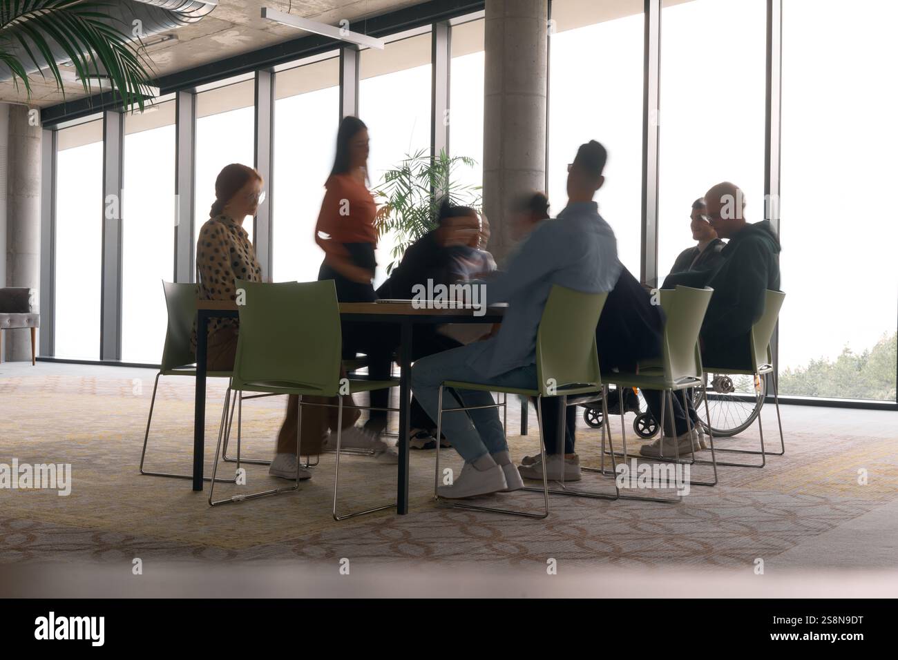 A diverse business team, working urgently around a conference table ...
