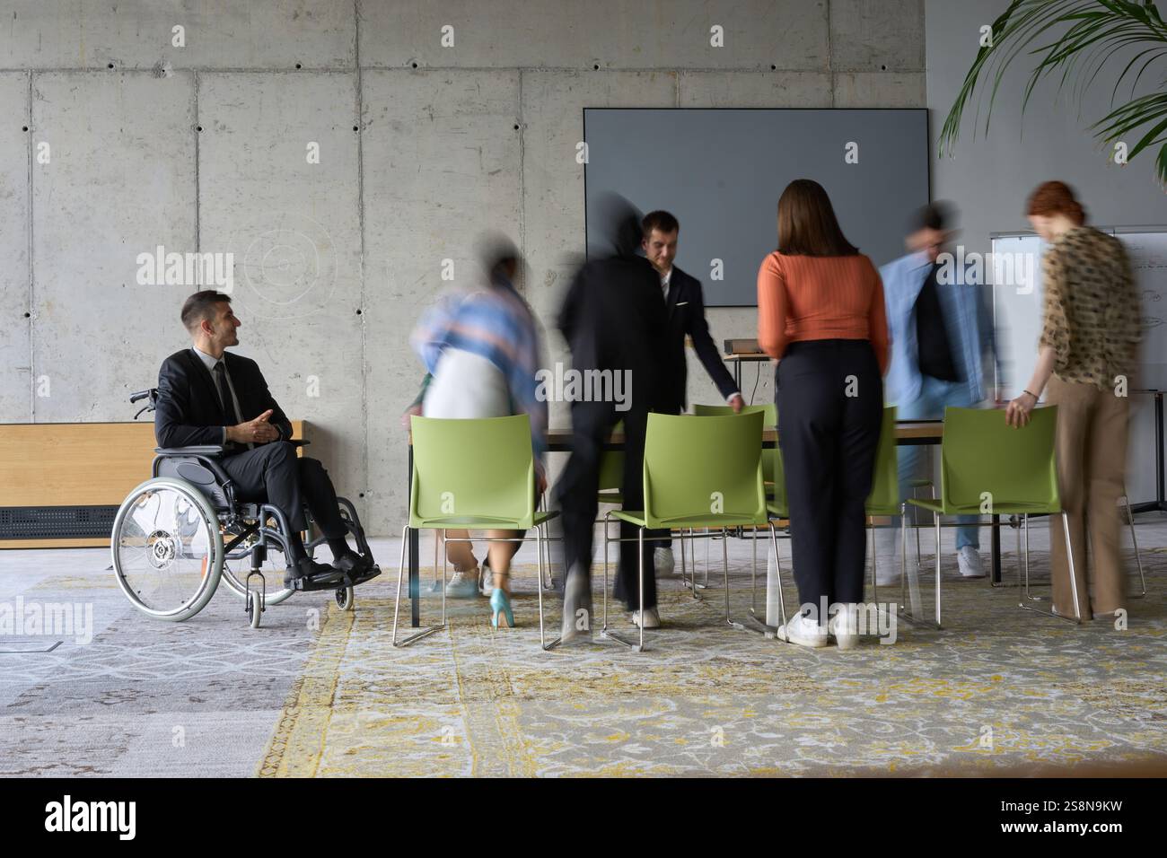 A diverse business team, working urgently around a conference table ...