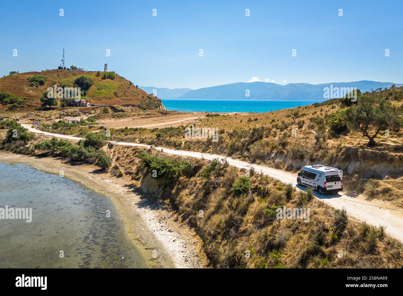 Camper van, RV or motor home is driving on gravel road from Zvernec ...