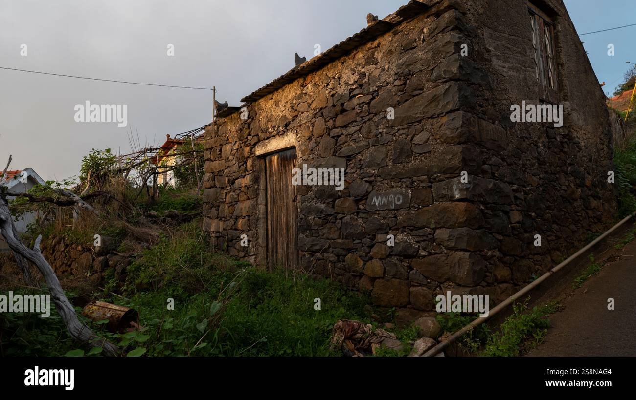 An old stone house with a wooden door, located on a hillside with ...