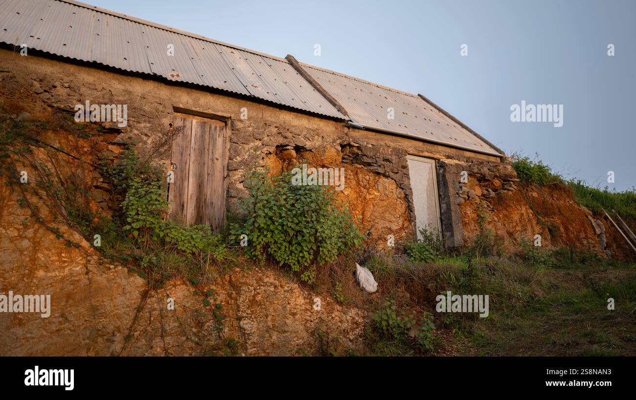 An old rural building with a weathered wooden door, built into an ...
