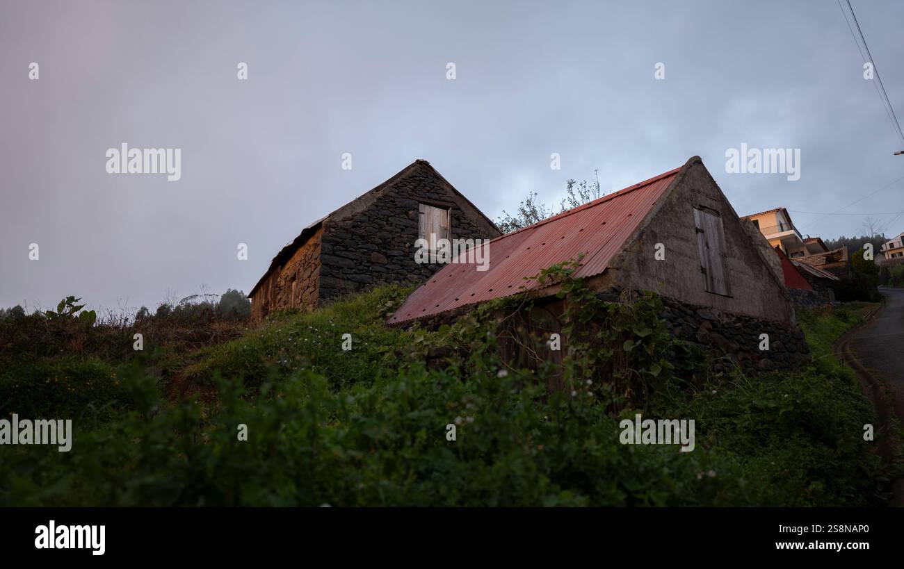 Two old rural houses with stone and concrete walls, featuring sloped ...
