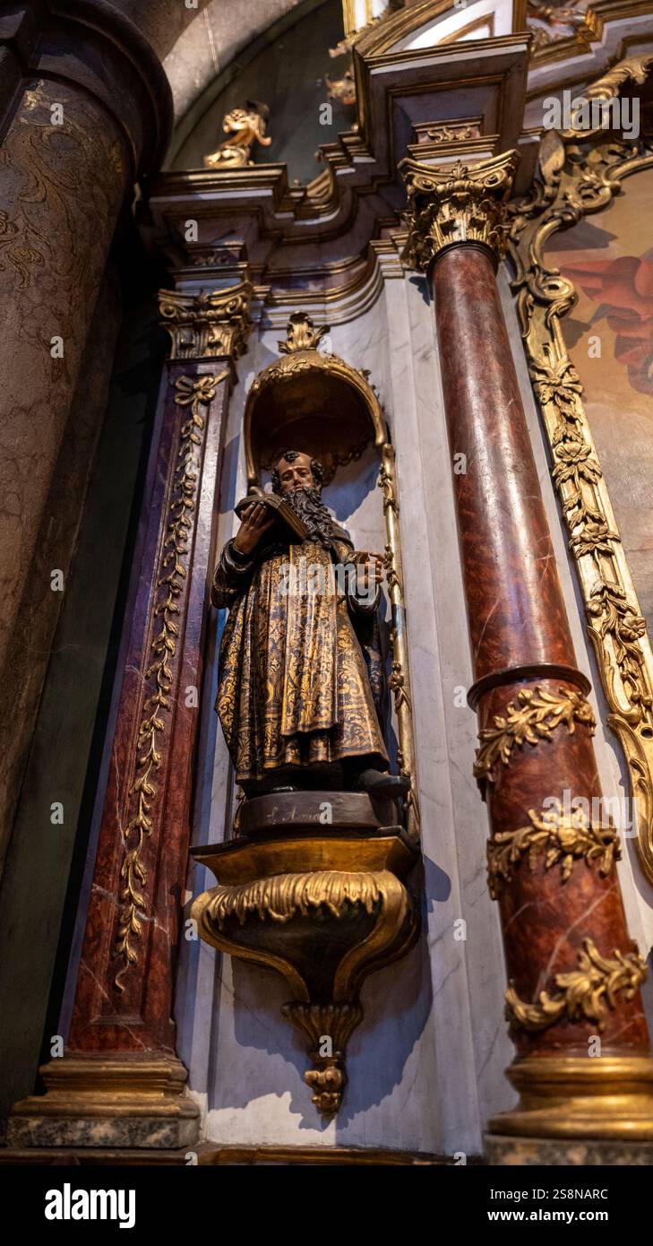 A detailed statue of a saint placed in an ornate niche, surrounded by ...