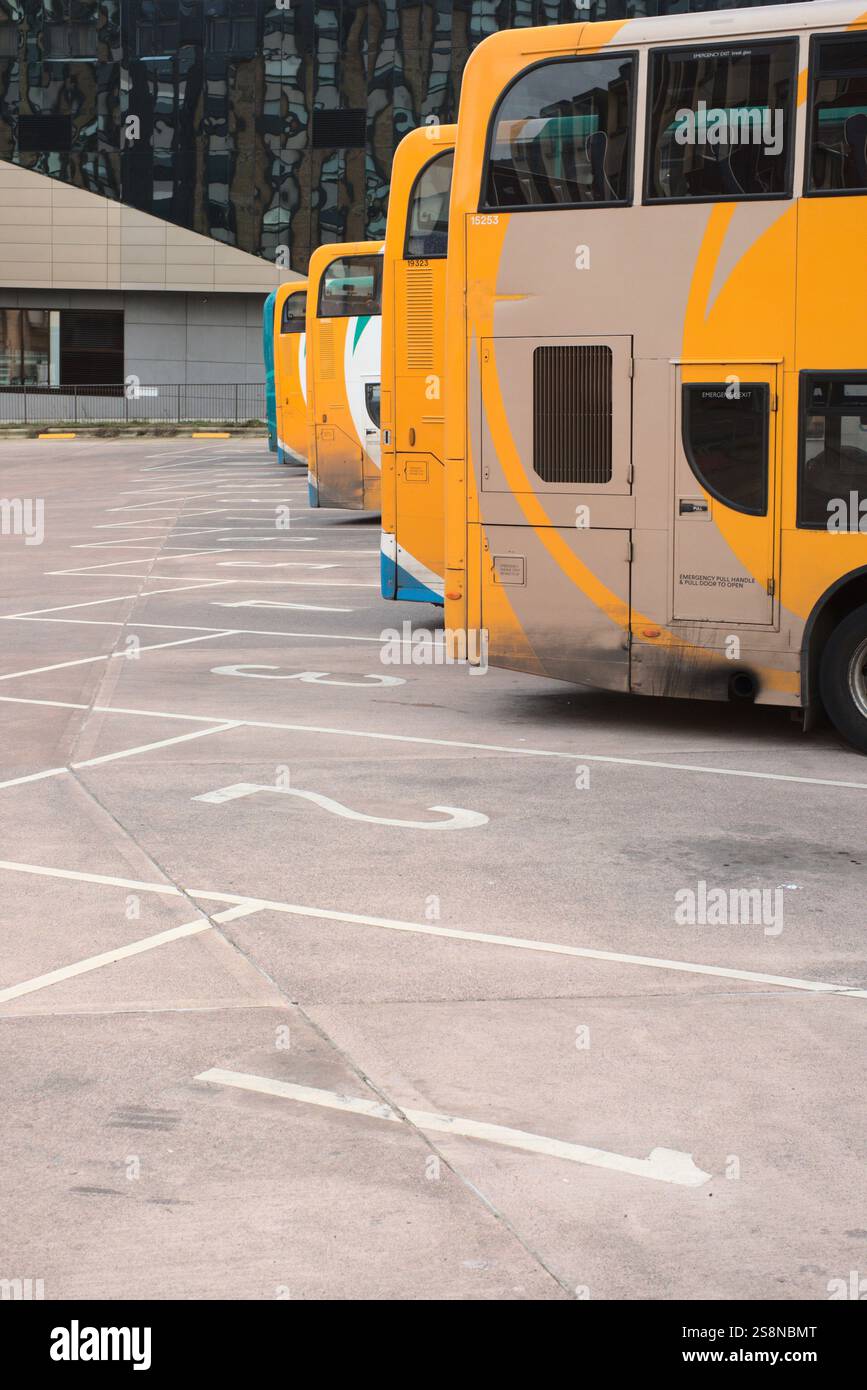 Public transport buses in numbered parking bays at bus station. Exeter ...