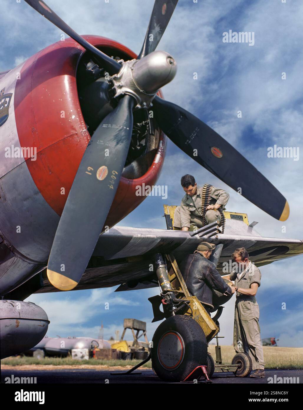 Armourers loading ammunition and bombs on a Republic P-47 Thunderbolt ...
