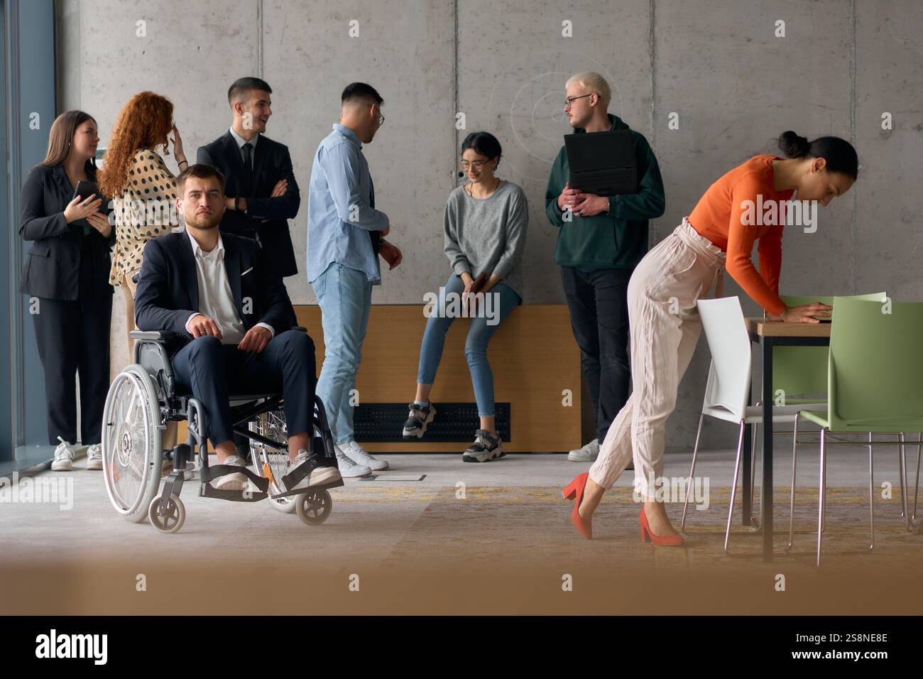 A diverse team of business professionals in a modern office stands ...