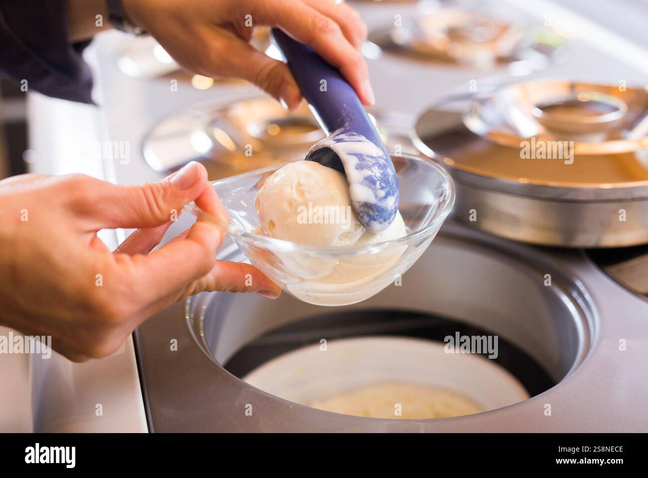 Scoop of creamy ice cream in spoon from the refrigerator container ...