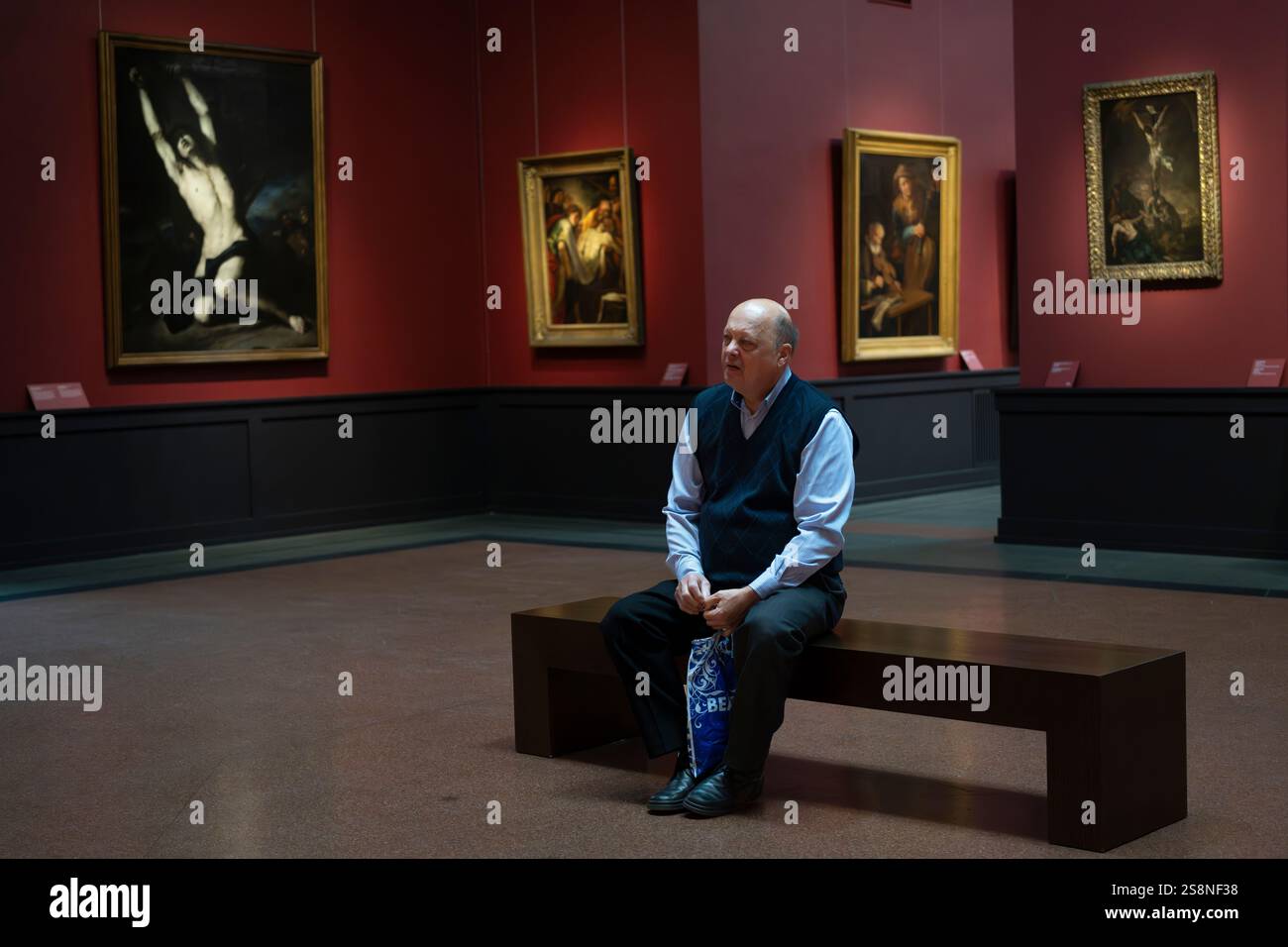 A visitor sits with the newly restored painting "Saint Sebastian" by ...