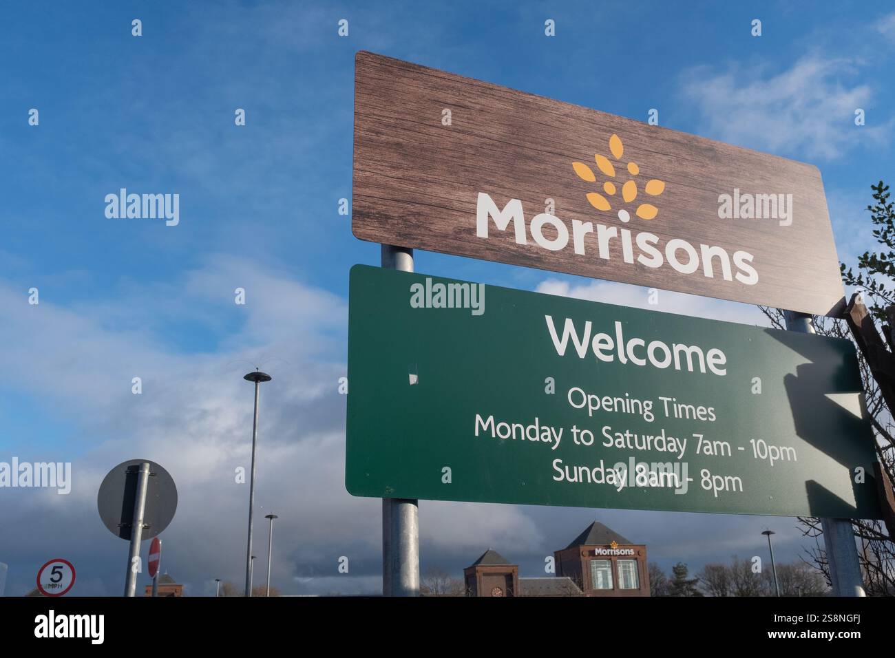 Winter sun highlights signage at an entrance to the Morrisons store in ...