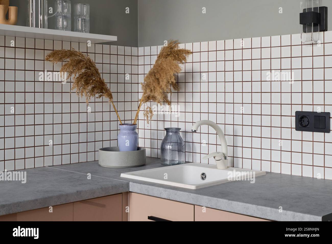 This modern kitchen corner features beige tiles and decorative elements ...