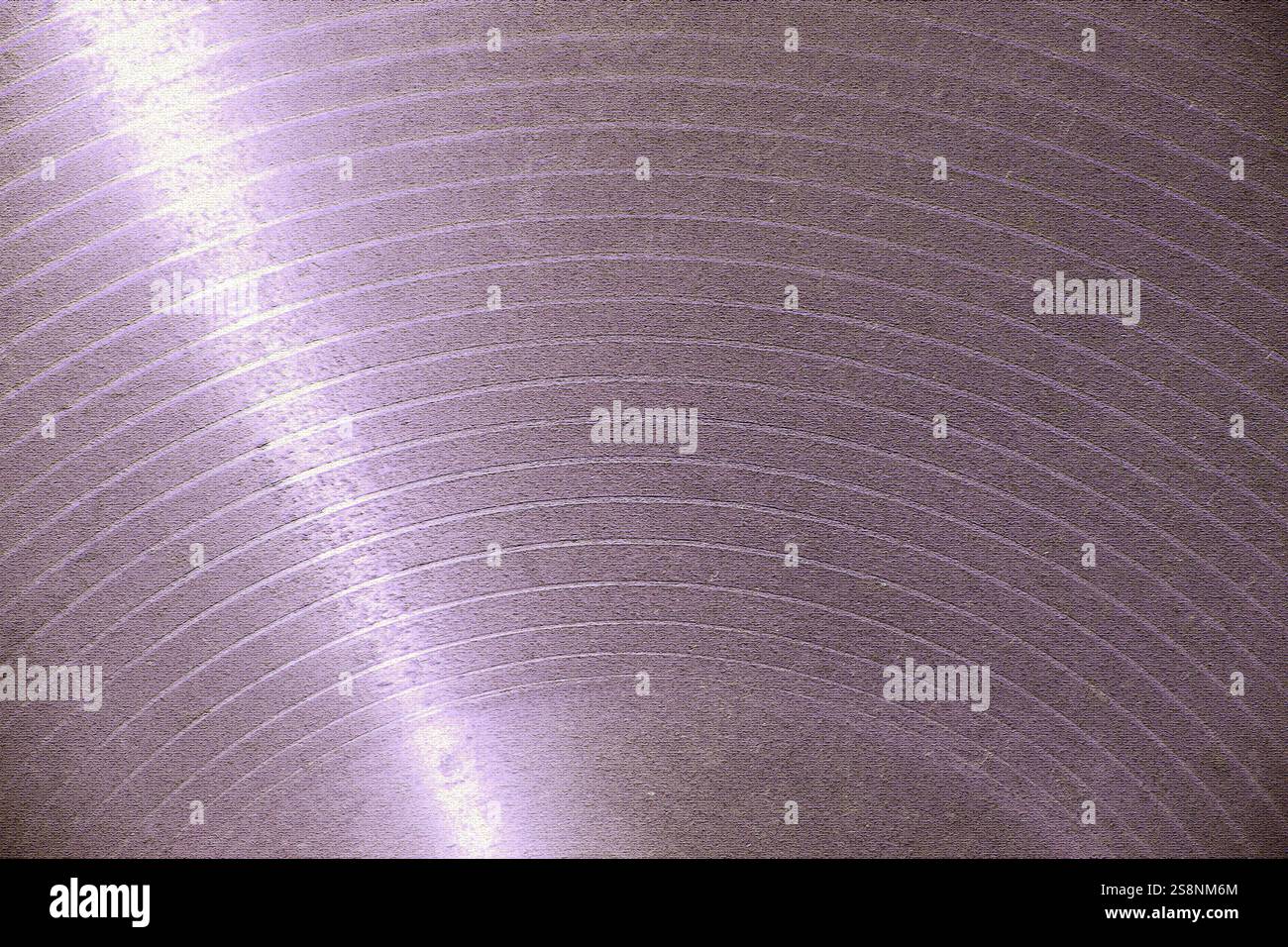Light is reflecting on a textured purple surface creating concentric circles, suggesting a sense ...