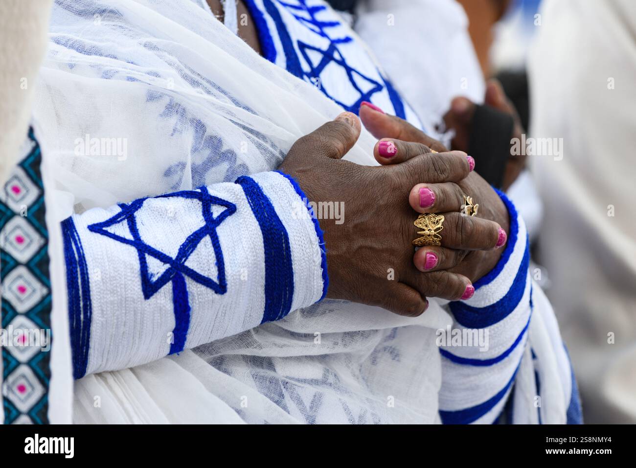 Closeup of the hands and white dress of an Ethiopian, Jewish woman ...