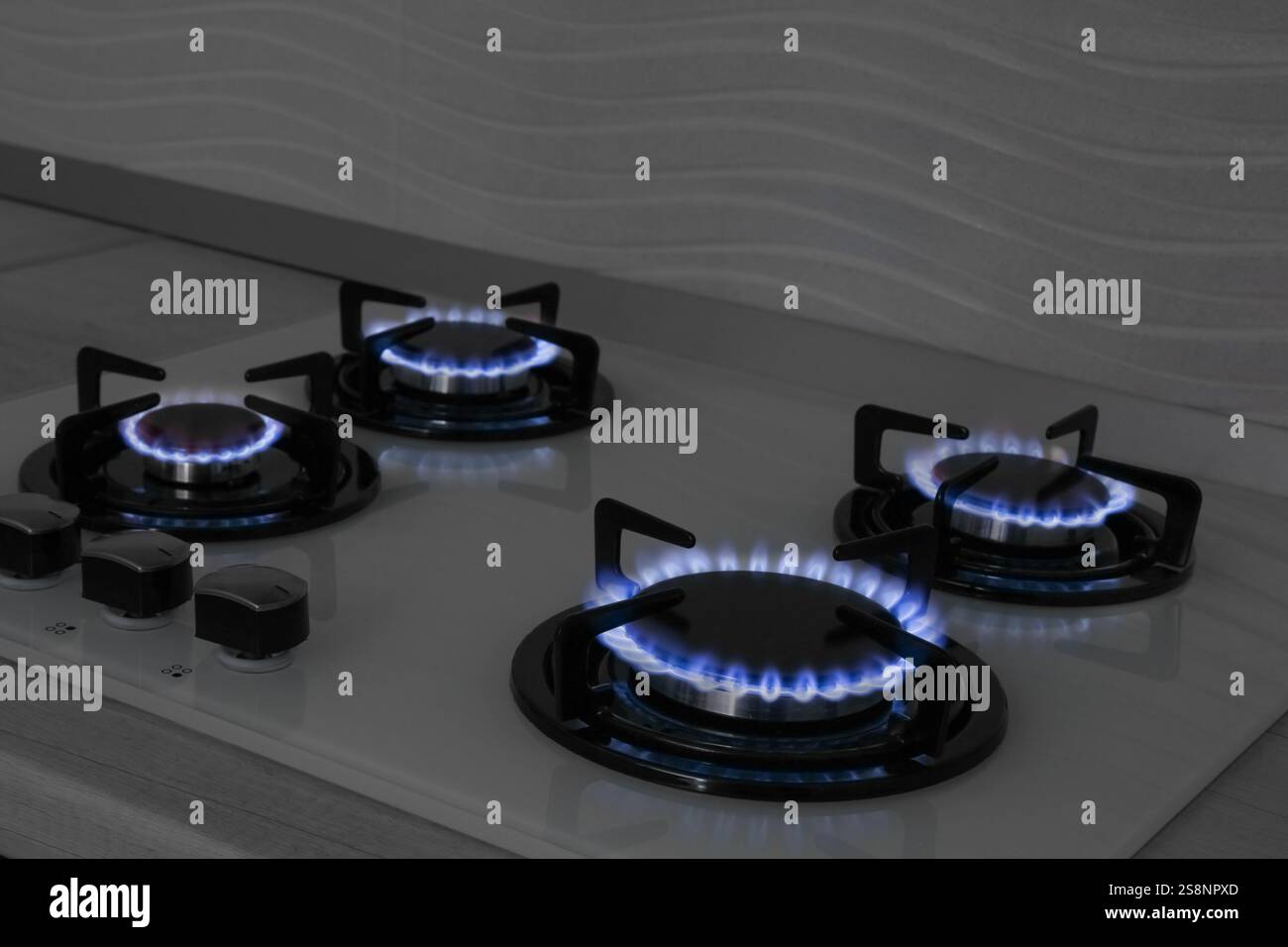 Modern gas cooktop with burning blue flames in kitchen Stock Photo - Alamy