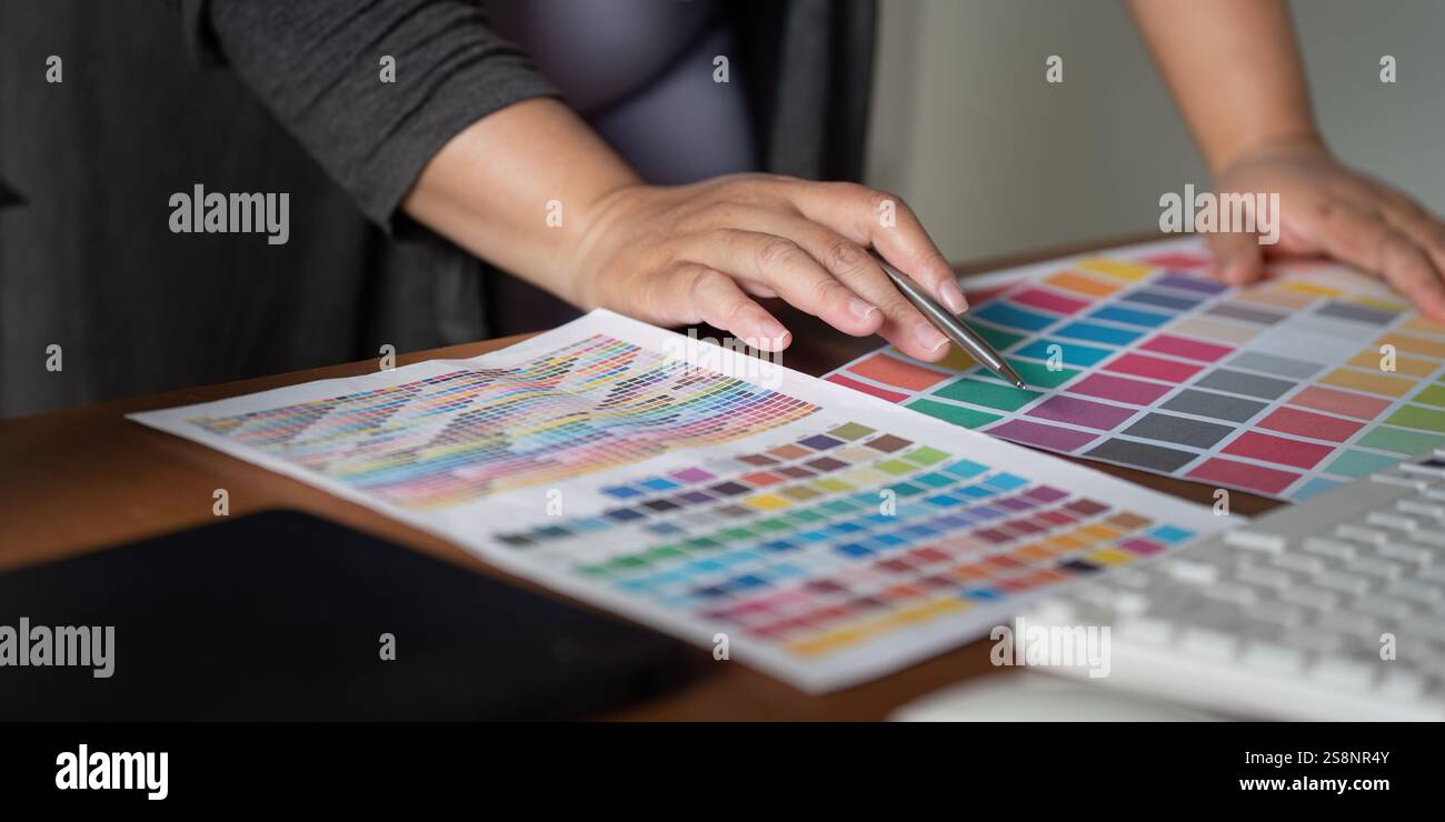 Focused graphic designer selecting color swatches and working on design ...