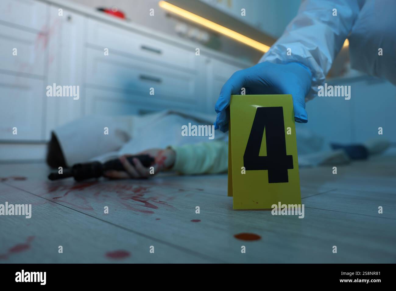 Forensic expert with numbered marker stand and dead body with gun at ...