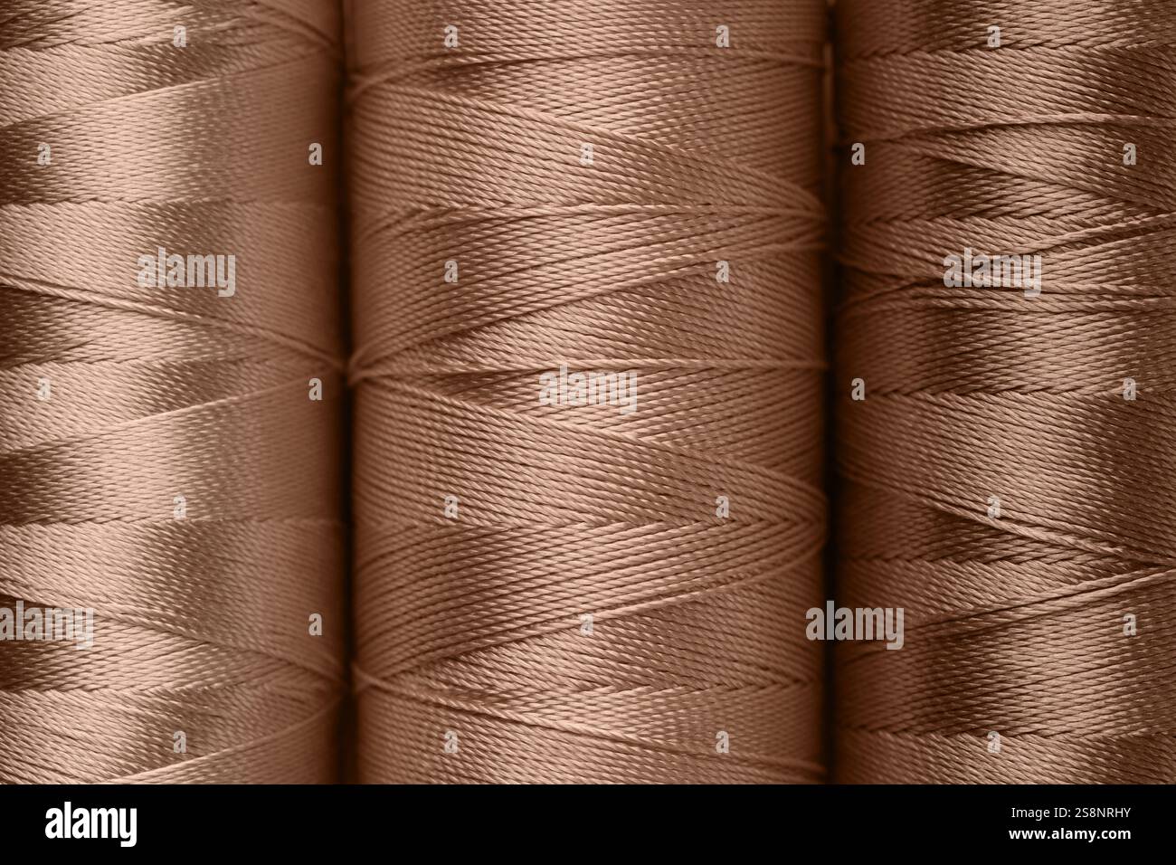 Sewing threads in mocha mousse shades, closeup. Trendy color of 2025 ...