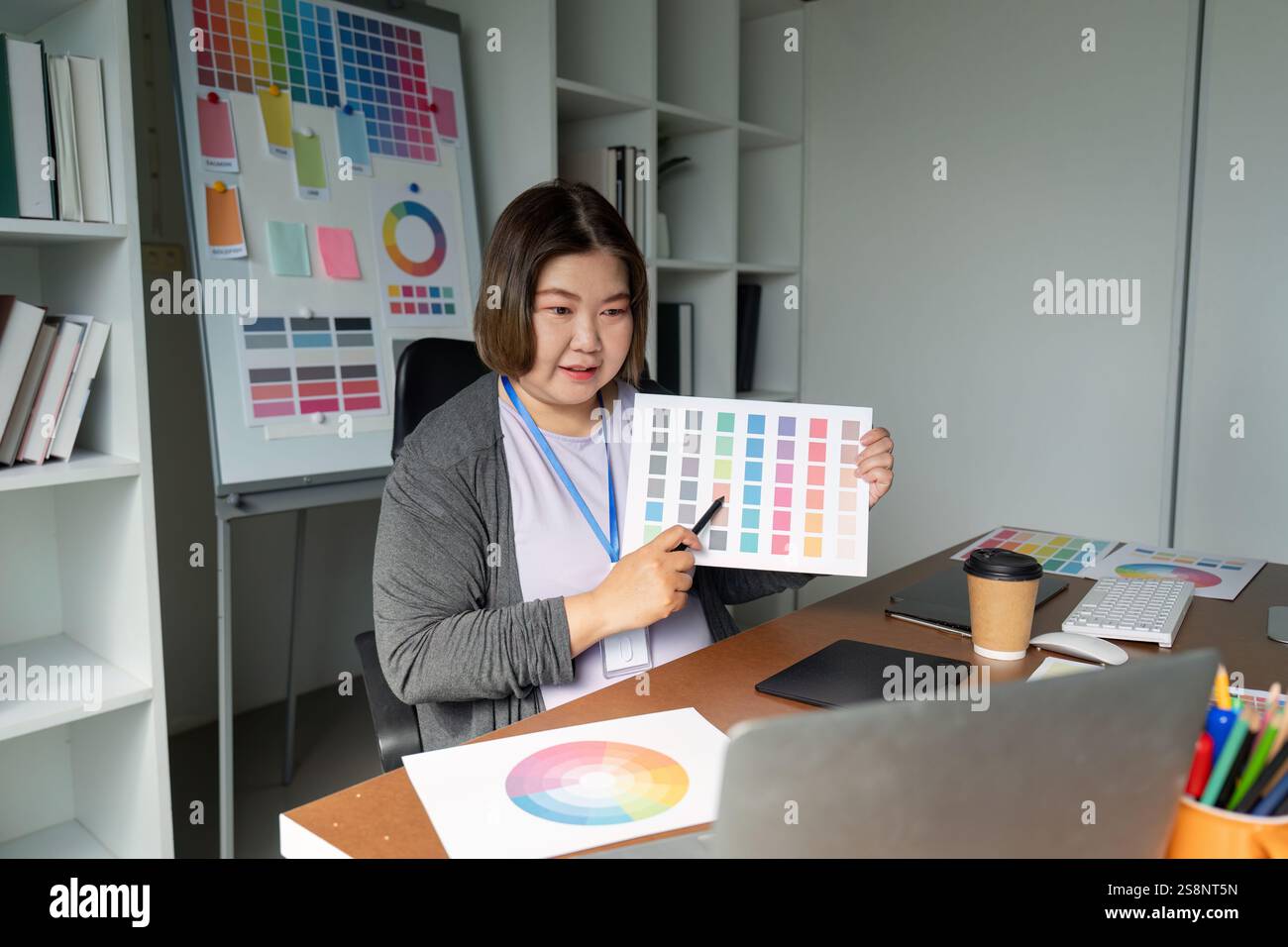 Graphic designer showcasing color palette options at her desk while ...