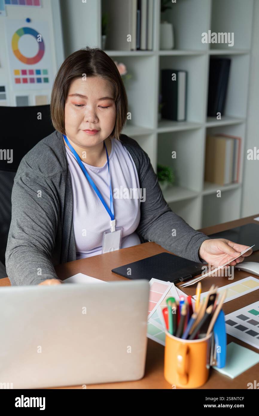 Graphic designer reviewing digital drafts on her laptop while ...