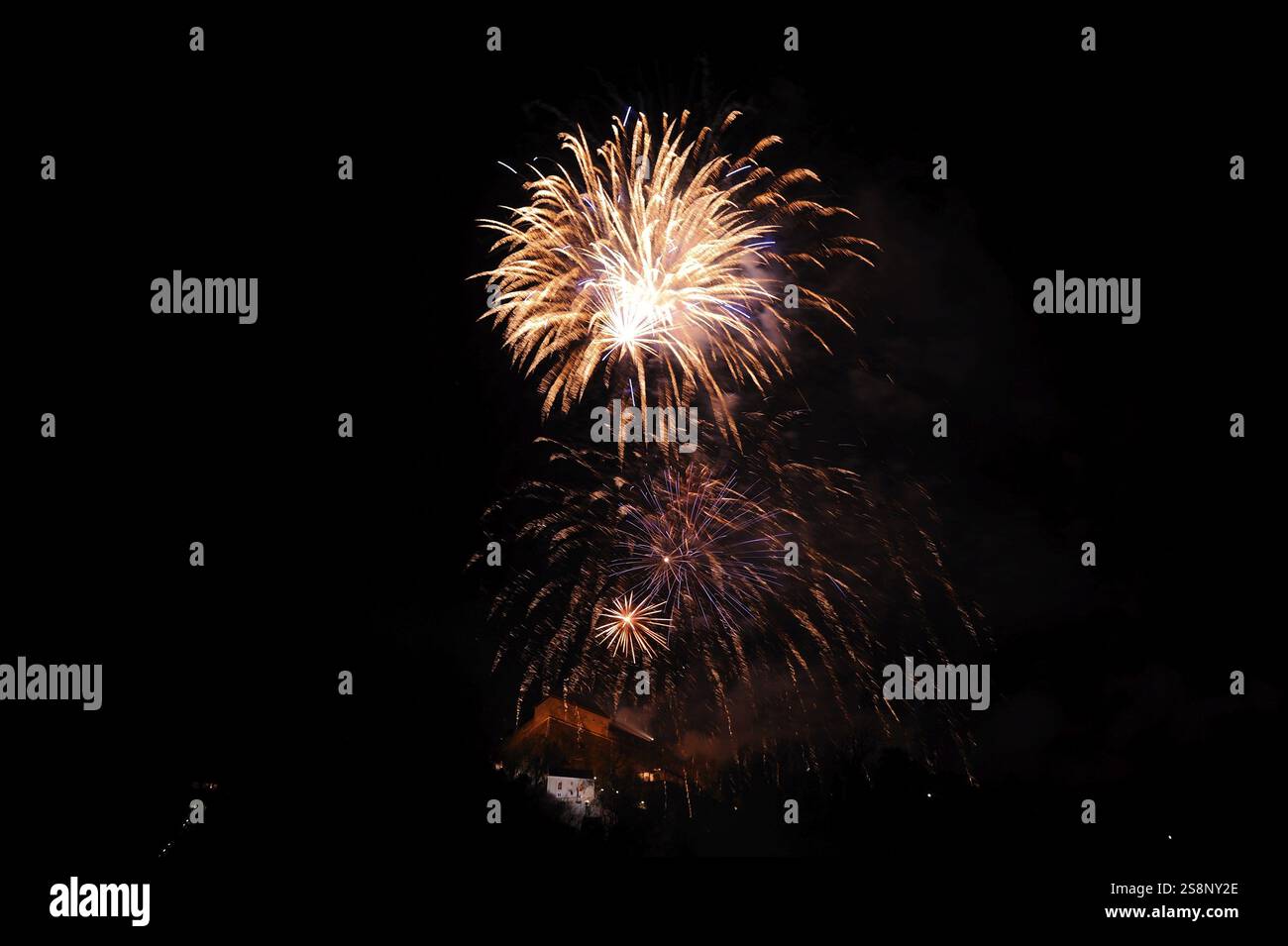 Orange-coloured fireworks unfold spectacularly in the night sky above a ...