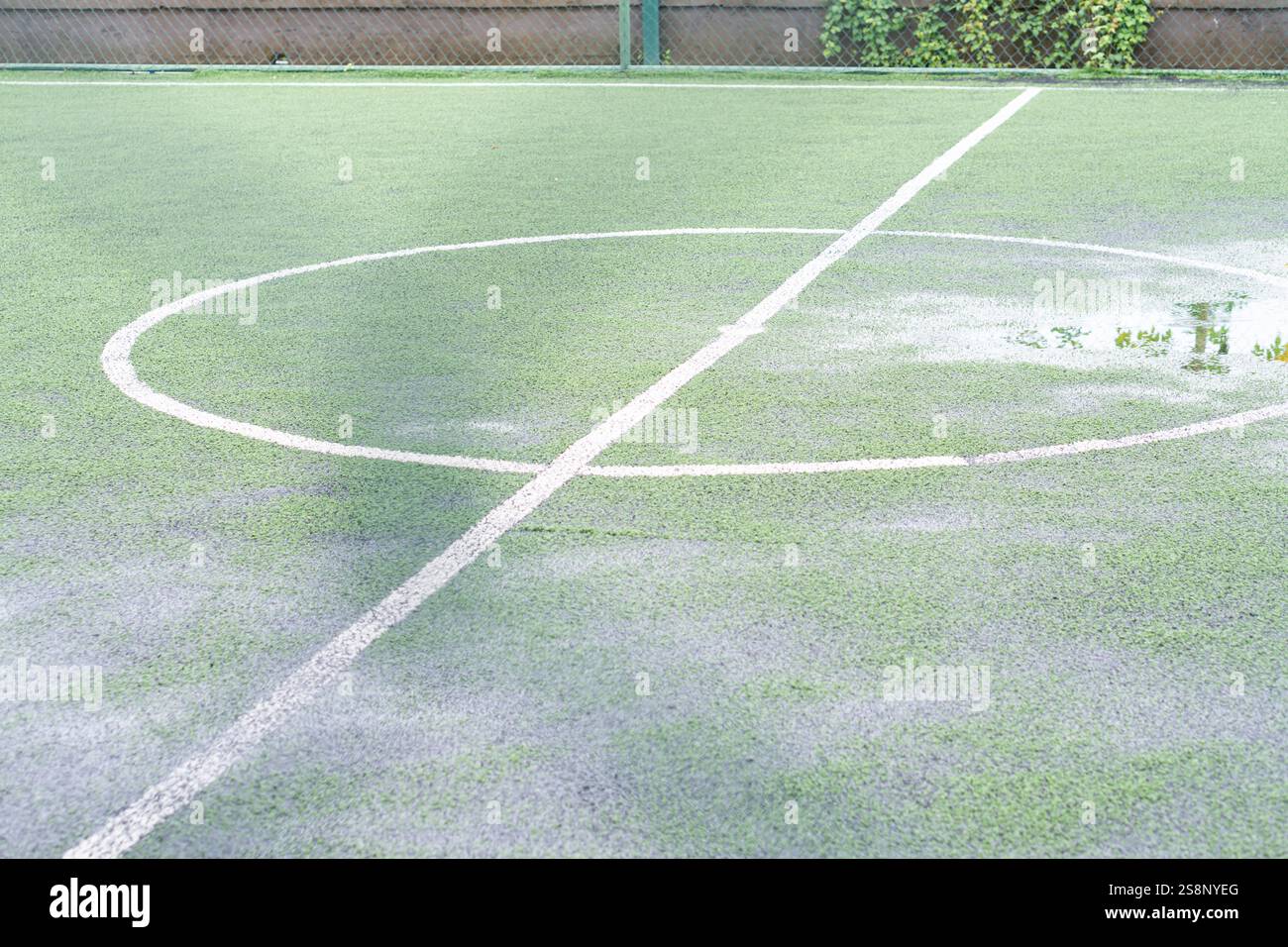 A close-up view of a soccer field with a circular center mark. The ...