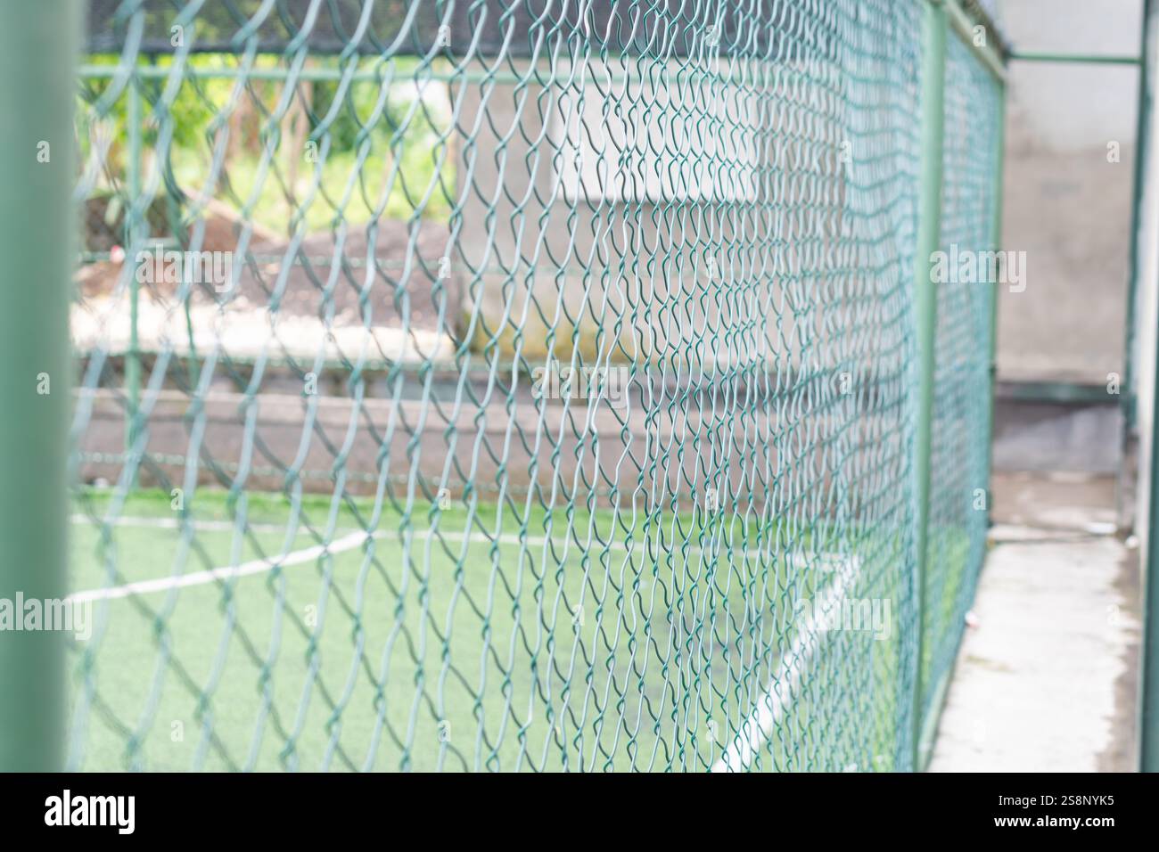 A close-up view of a green chain-link fence surrounding a sports court ...