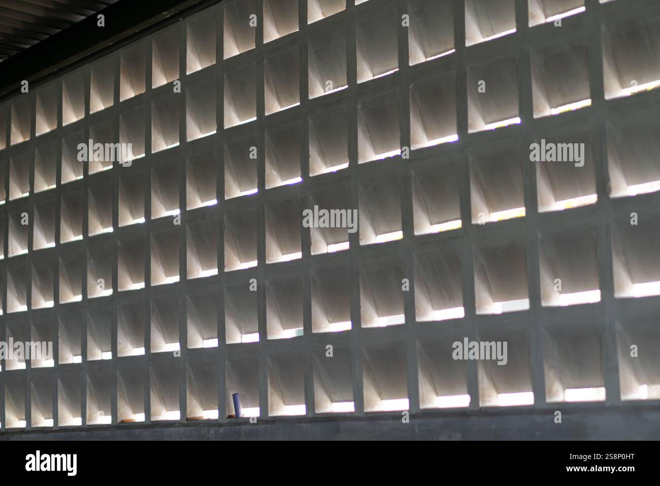 A wall featuring a grid of square openings that create a pattern of ...