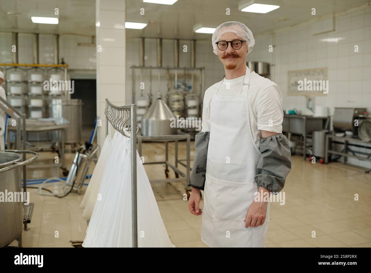 Portrait of industrial worker standing in processing facility with ...