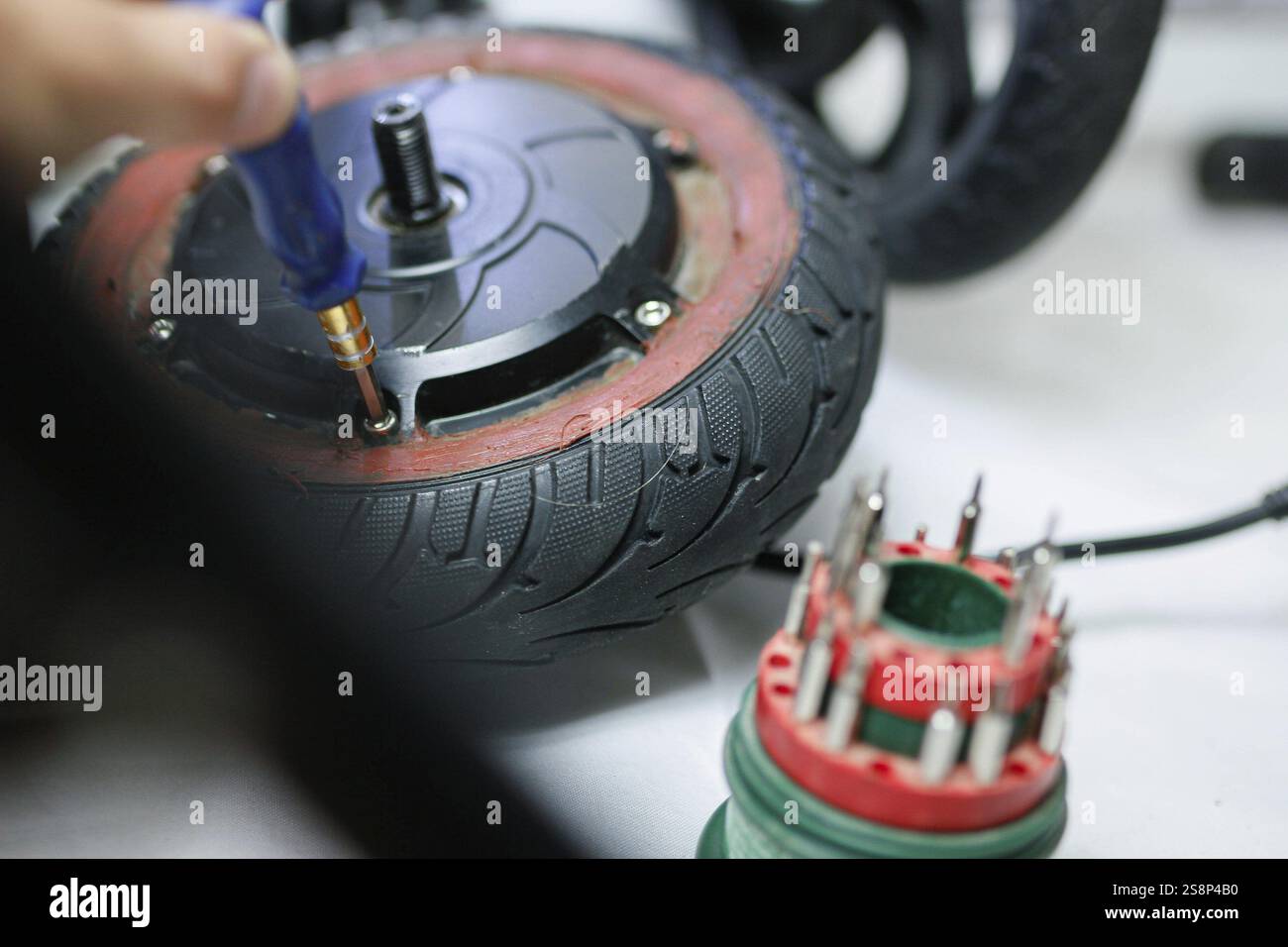 Precision tool work on a scooter wheel highlighting mechanical repair ...