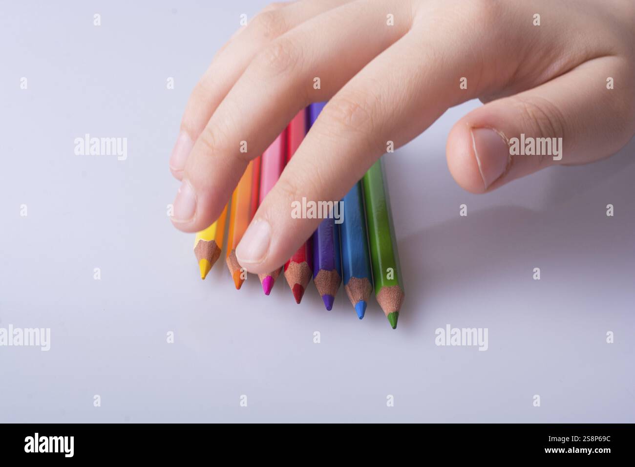 Hand holding color Pencils placed on a white background Stock Photo - Alamy