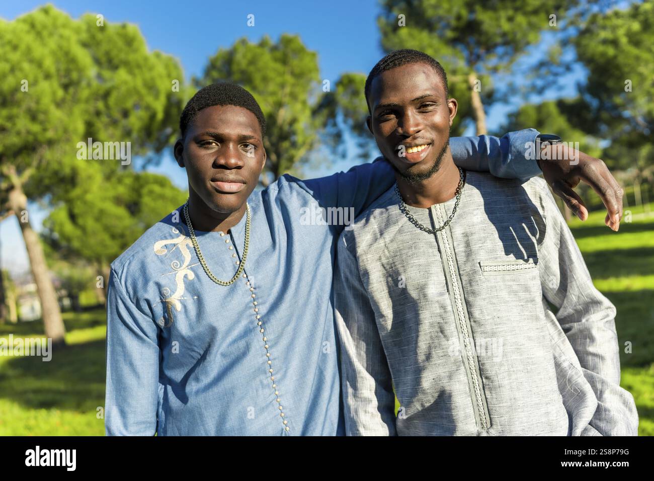 Two young senegalese men wearing traditional dashiki clothing embrace ...