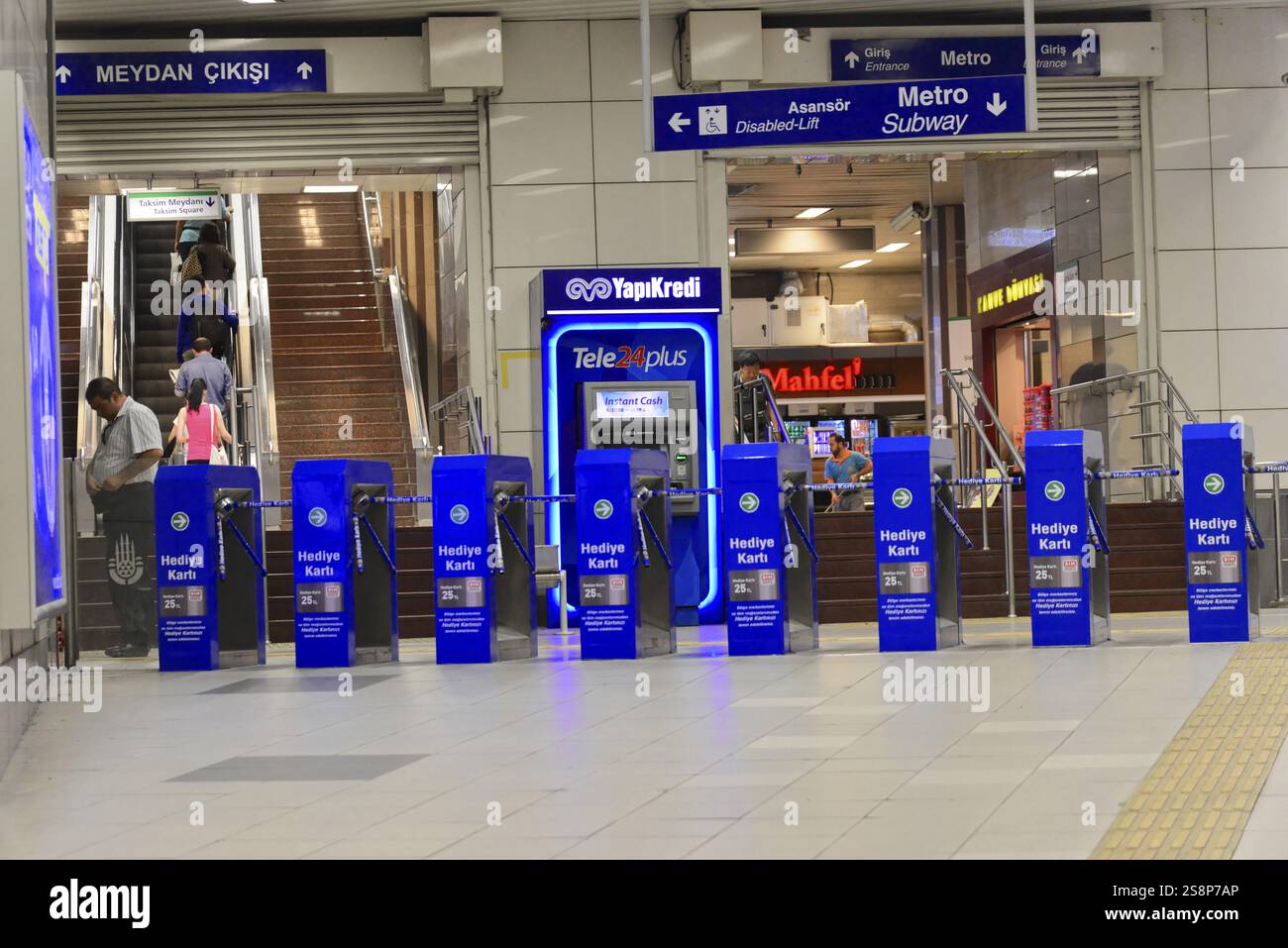 Station entrance with barriers, escalators and shops, Istanbul ...