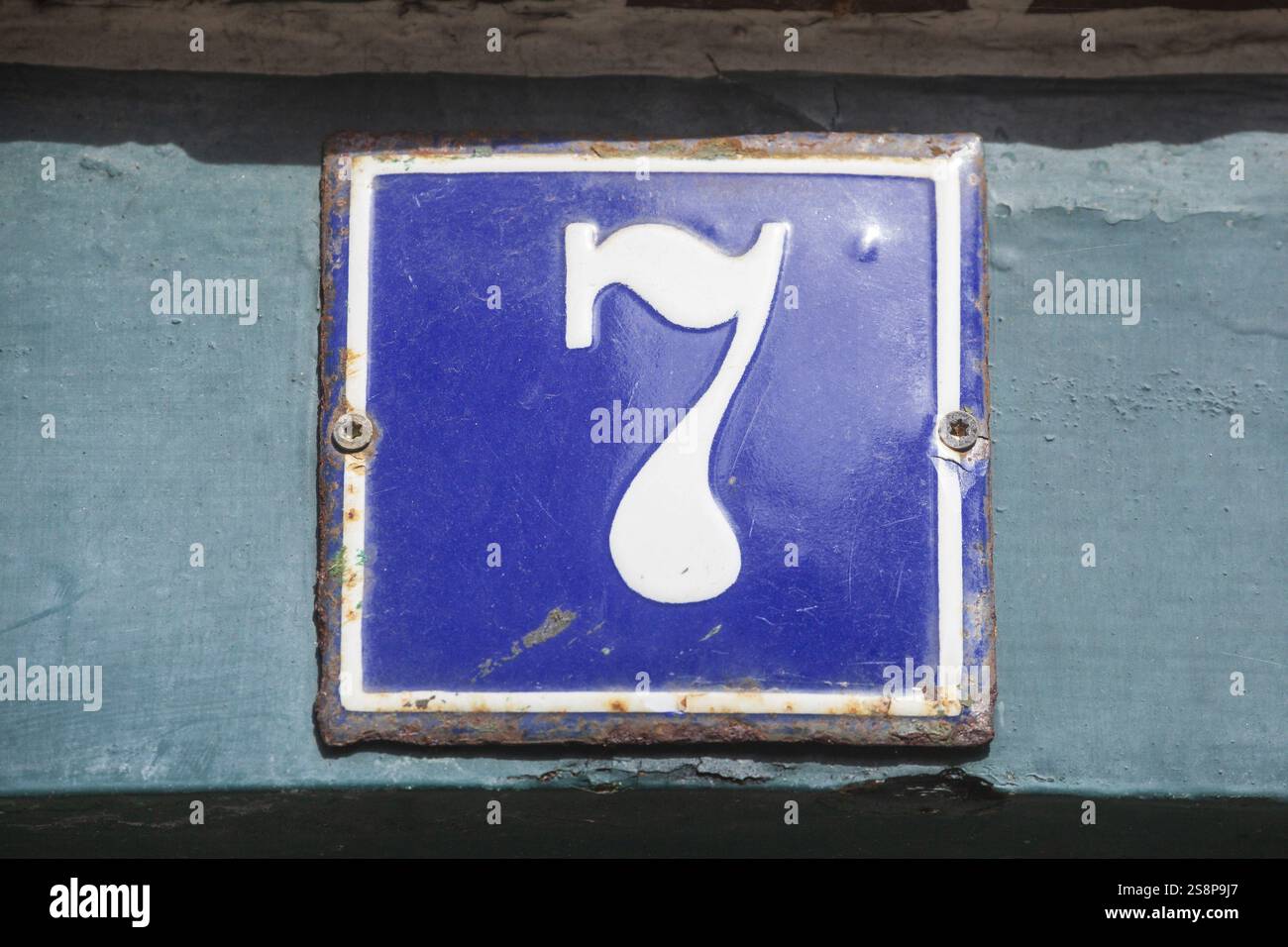 Blue house number plate number 7 on an old half-timbered beam ...