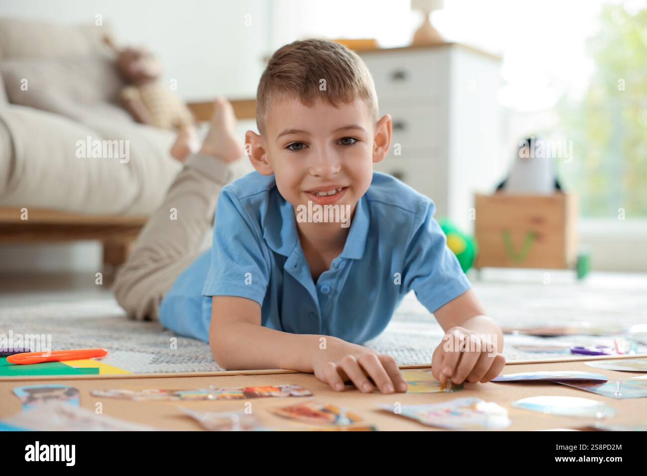 Little boy creating vision board with different pictures and other ...