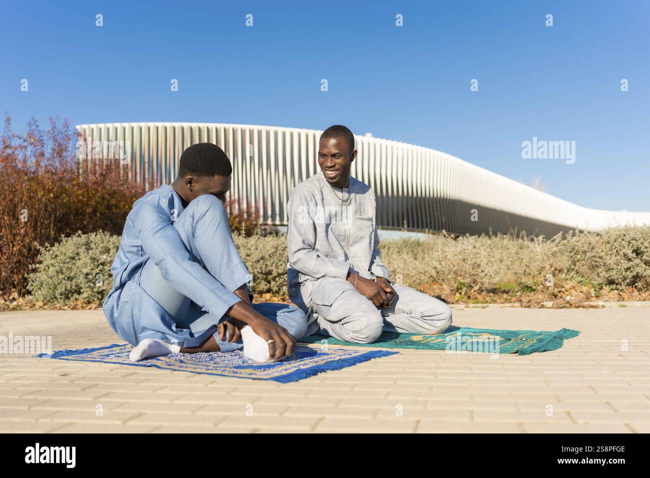 Two senegalese men wearing traditional clothing are preparing to pray ...