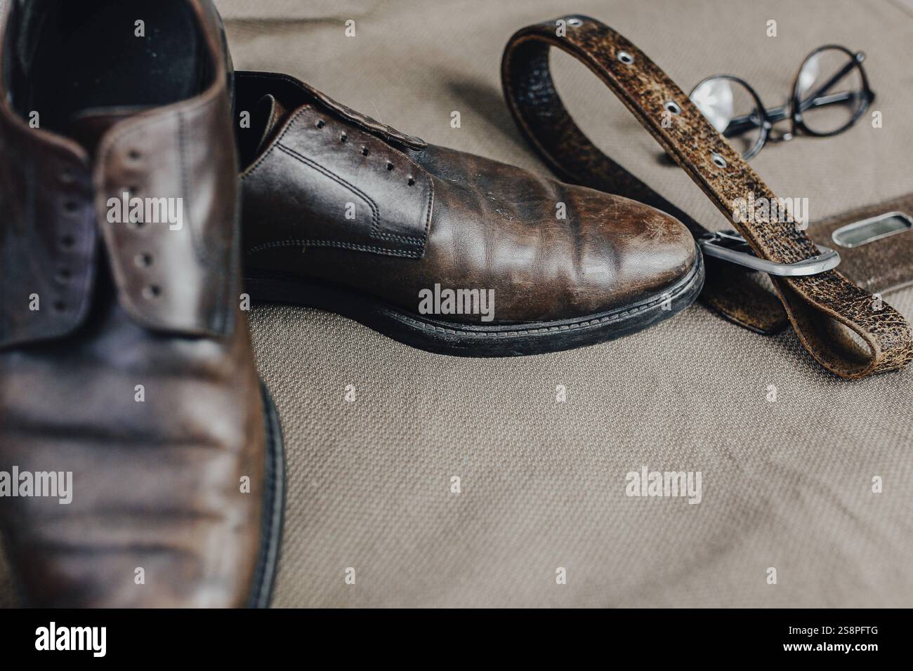Sophisticated setting with brown leather shoes and accessories on a ...