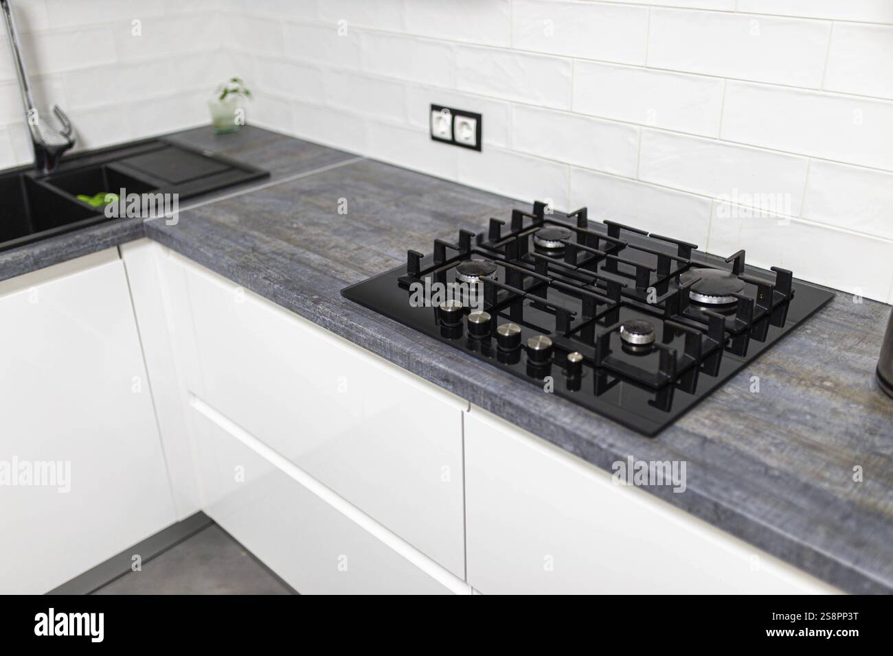 A modern kitchen featuring a gas stove on a wooden countertop Stock ...