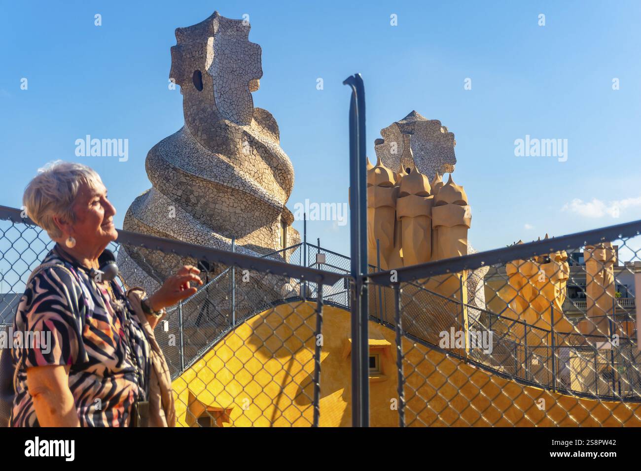 Senior tourist admiring the whimsical chimneys and vibrant architecture ...