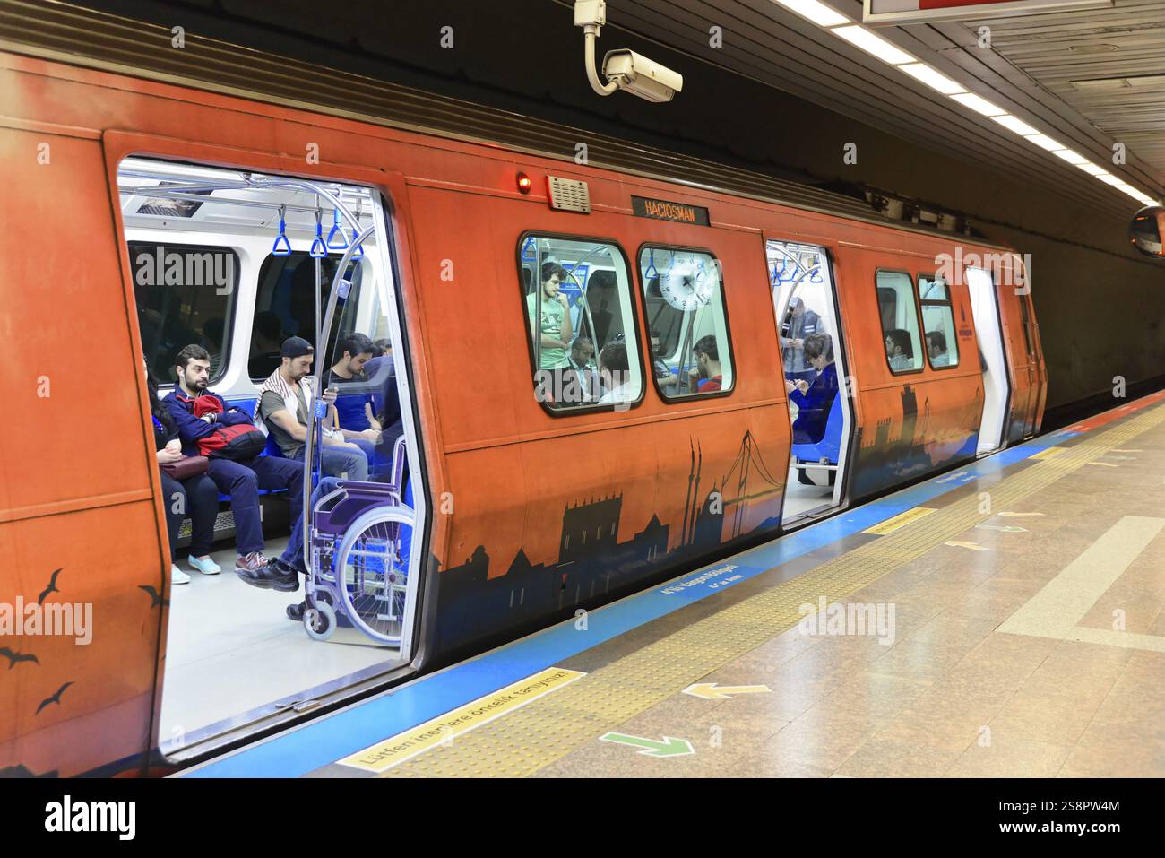 Orange metro train with open doors and passengers on board, Istanbul ...