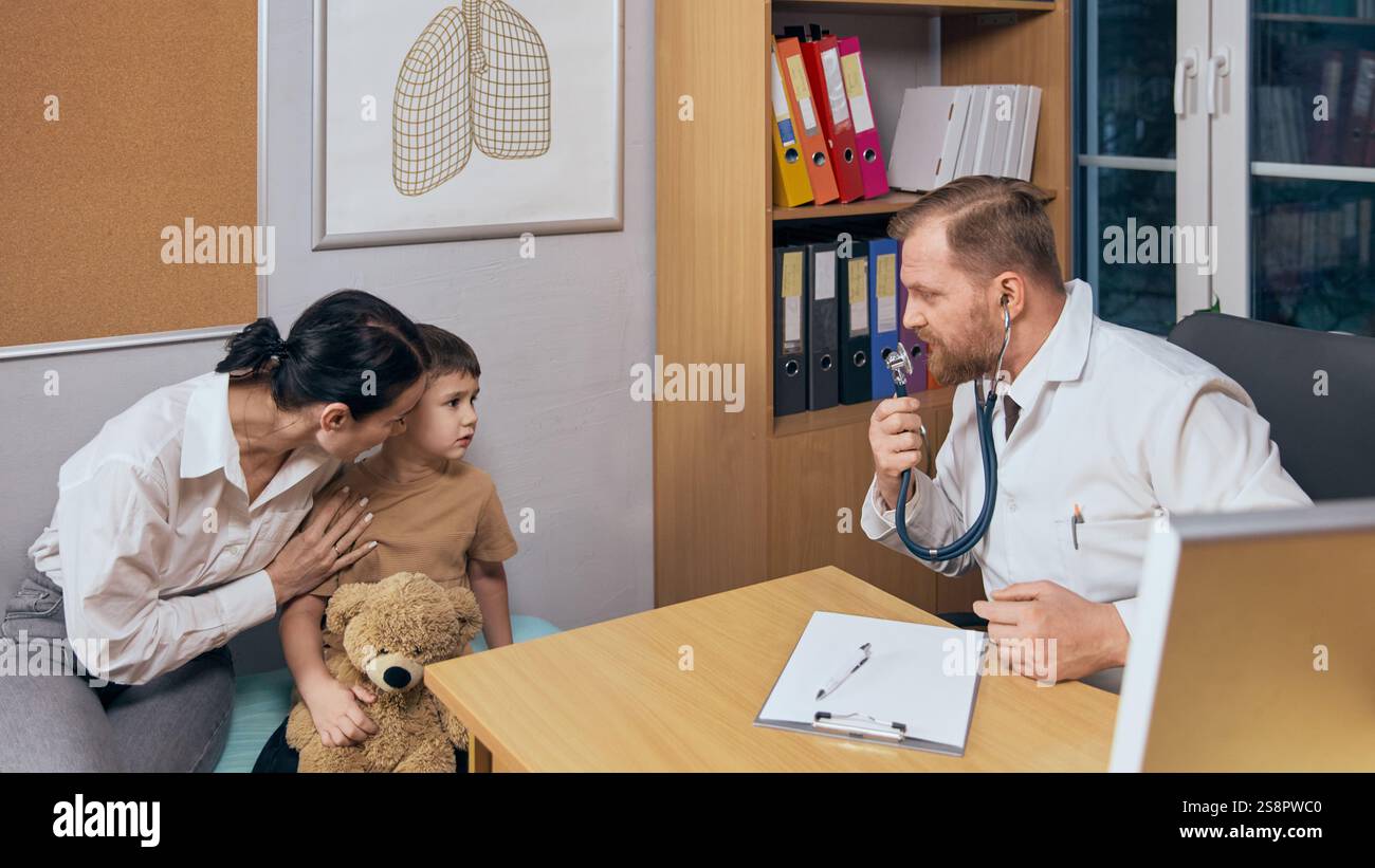 Male pediatrician with beard using stethoscope while examining ...