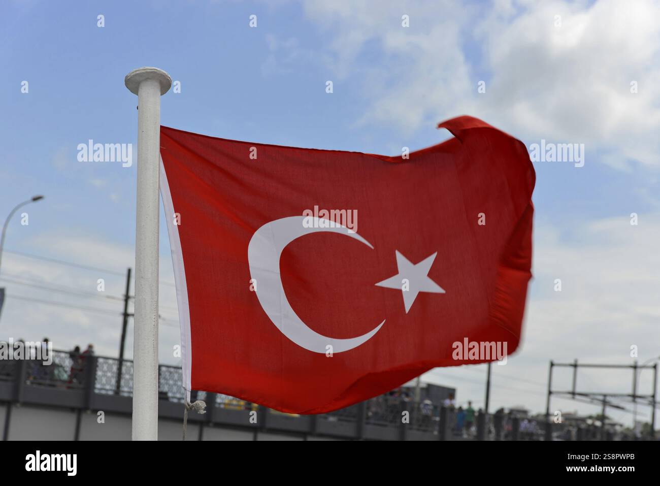 Turkish flag with crescent and star waving in the wind under a blue sky ...
