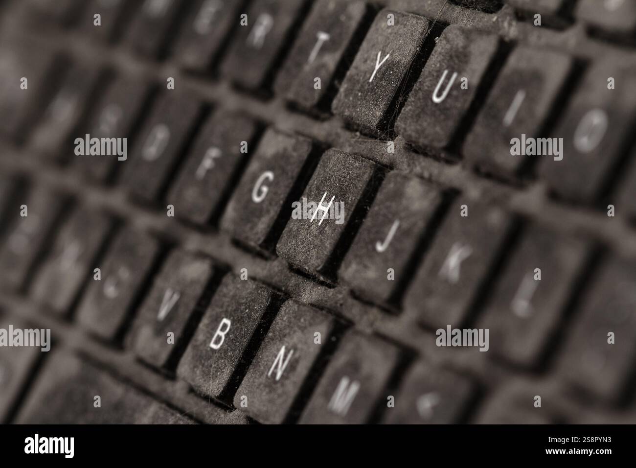 front view closeup of old black keyboard with keys covered in dust and ...