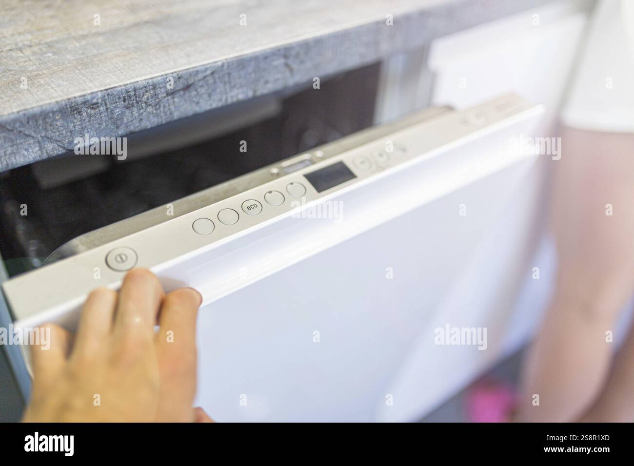 A person opening a dishwasher in a modern kitchen environment Stock ...